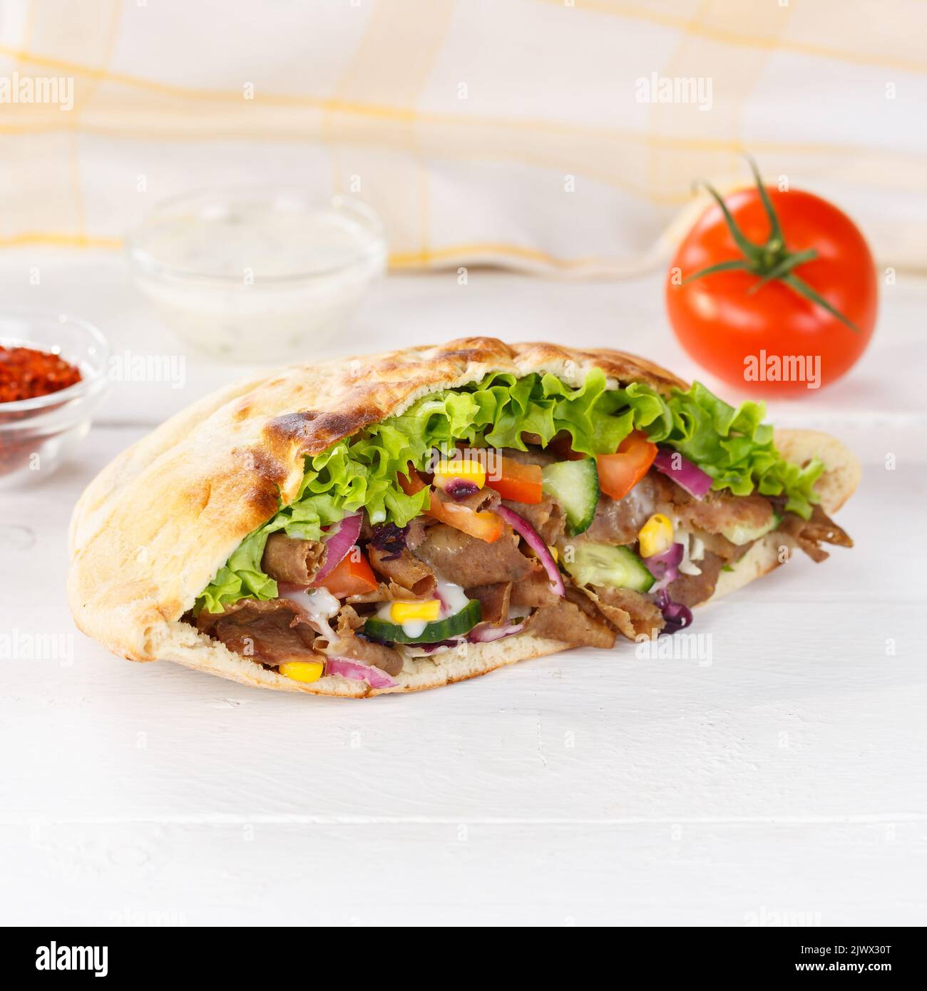 Döner Kebab Doner Kebap fast food in flatbread on a wooden board square ...