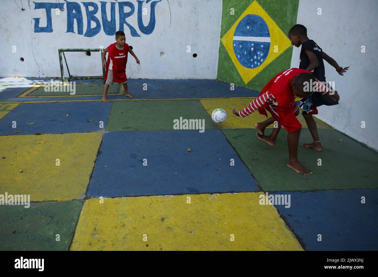 Local kids play football on a pitch in the favela of Jaburu in Vitoria ...
