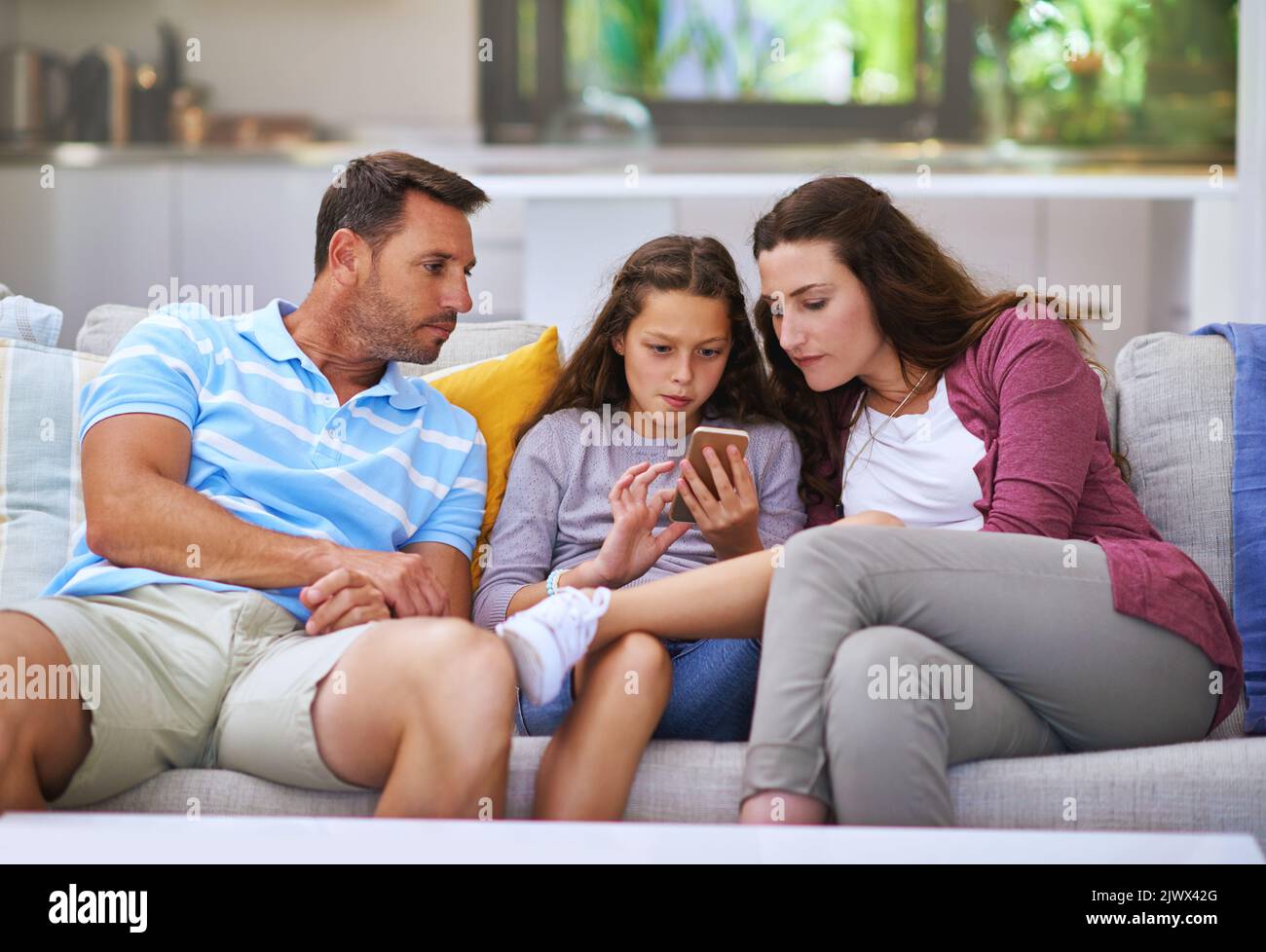 Take a look at this. a young girl showing her parents something on her ...