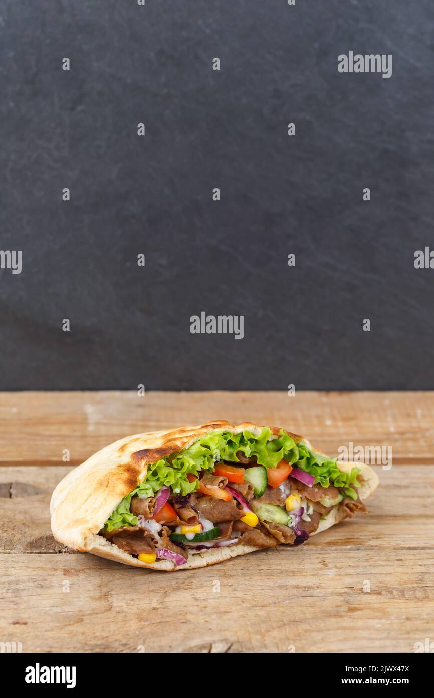 Döner Kebab Doner Kebap fast food in flatbread on a wooden board ...