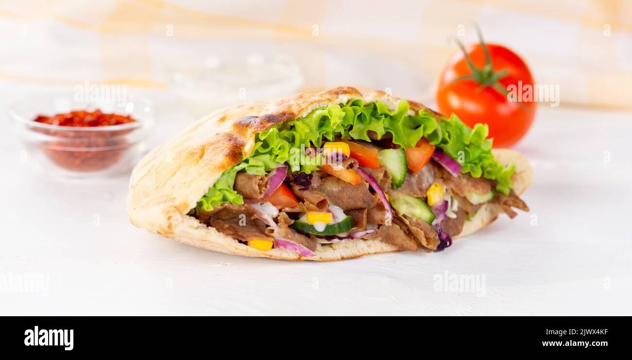 Döner Kebab Doner Kebap fast food in flatbread on a wooden board ...