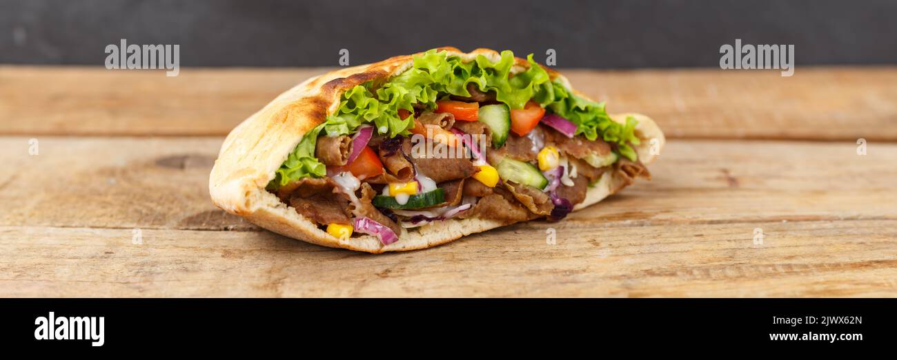 Döner Kebab Doner Kebap fast food in flatbread on a wooden board ...