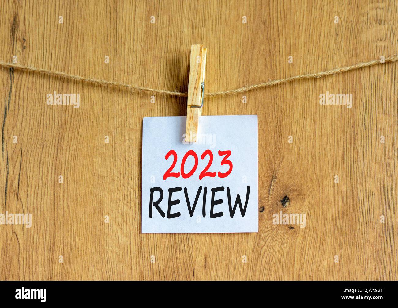 2023 Review symbol. White paper with words 2023 Review, clip on wooden ...