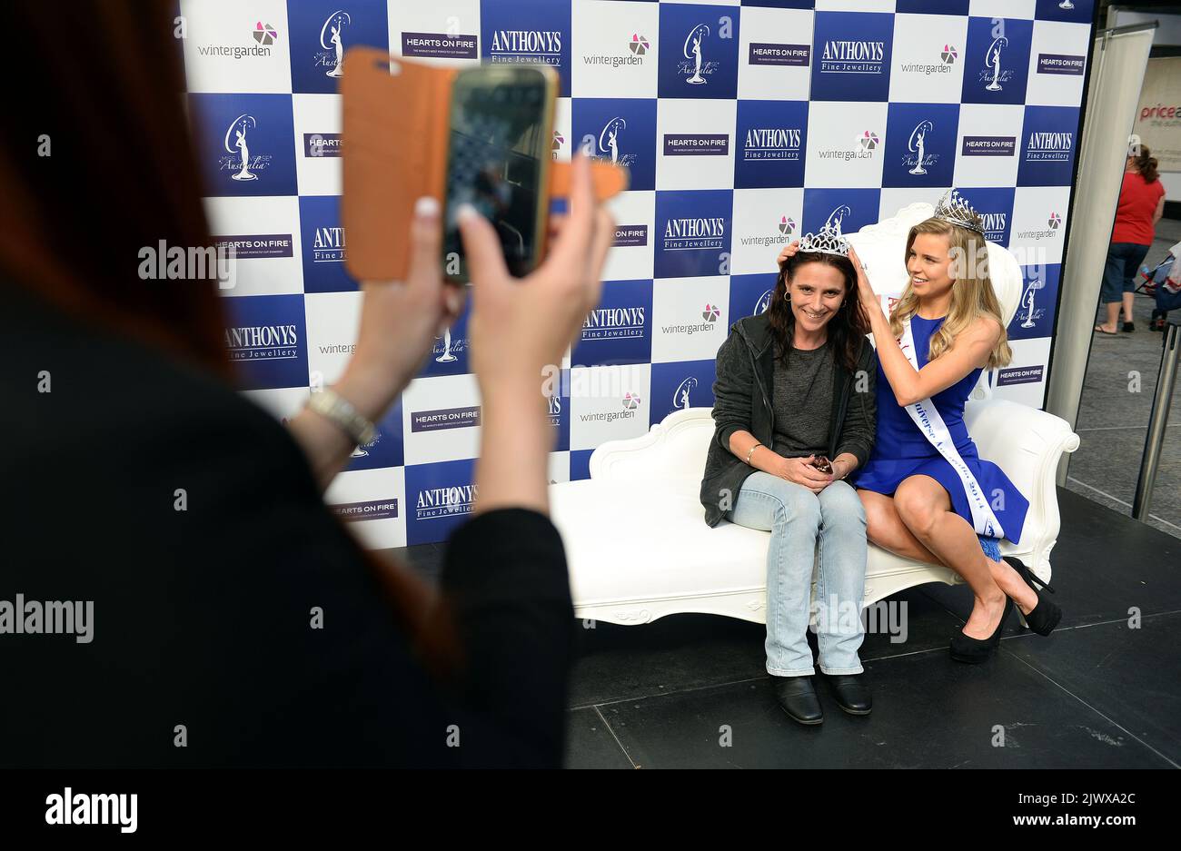 The newly crowned Miss Universe Australia Tegan Martin (right) adjusts ...