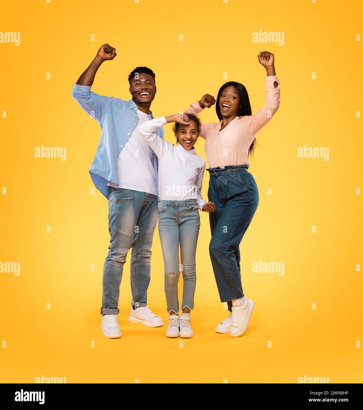 Victory concept. Excited african american family shaking clenched fists ...