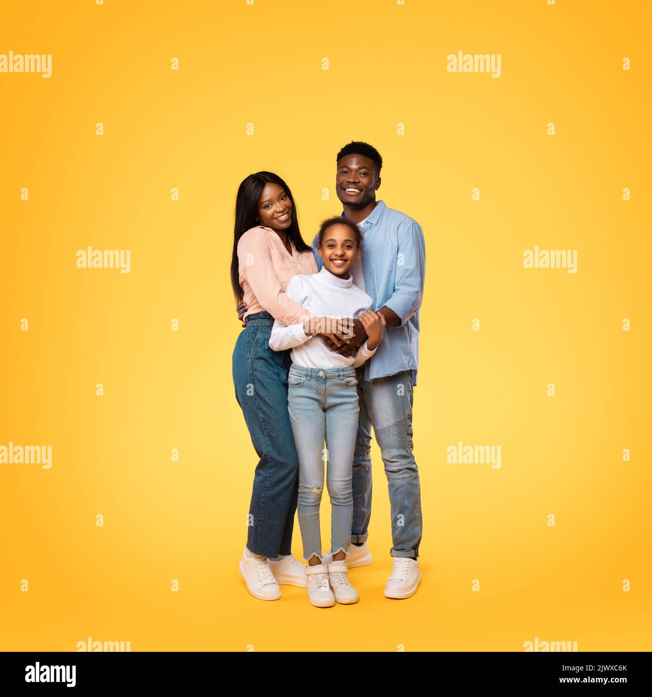Portrait of happy black family of three embracing and posing together ...