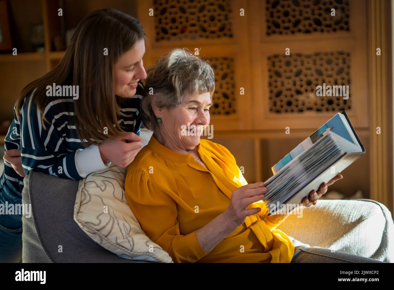 Old woman with her granddaughter look at family photos Stock Photo - Alamy