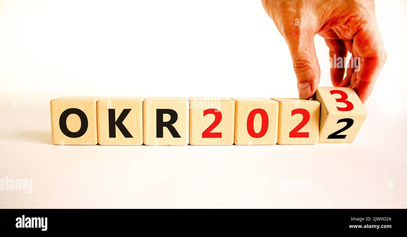 OKR, objectives and key results symbol. Businessman turns cubes with words OKR 2022 and OKR 2023 ...