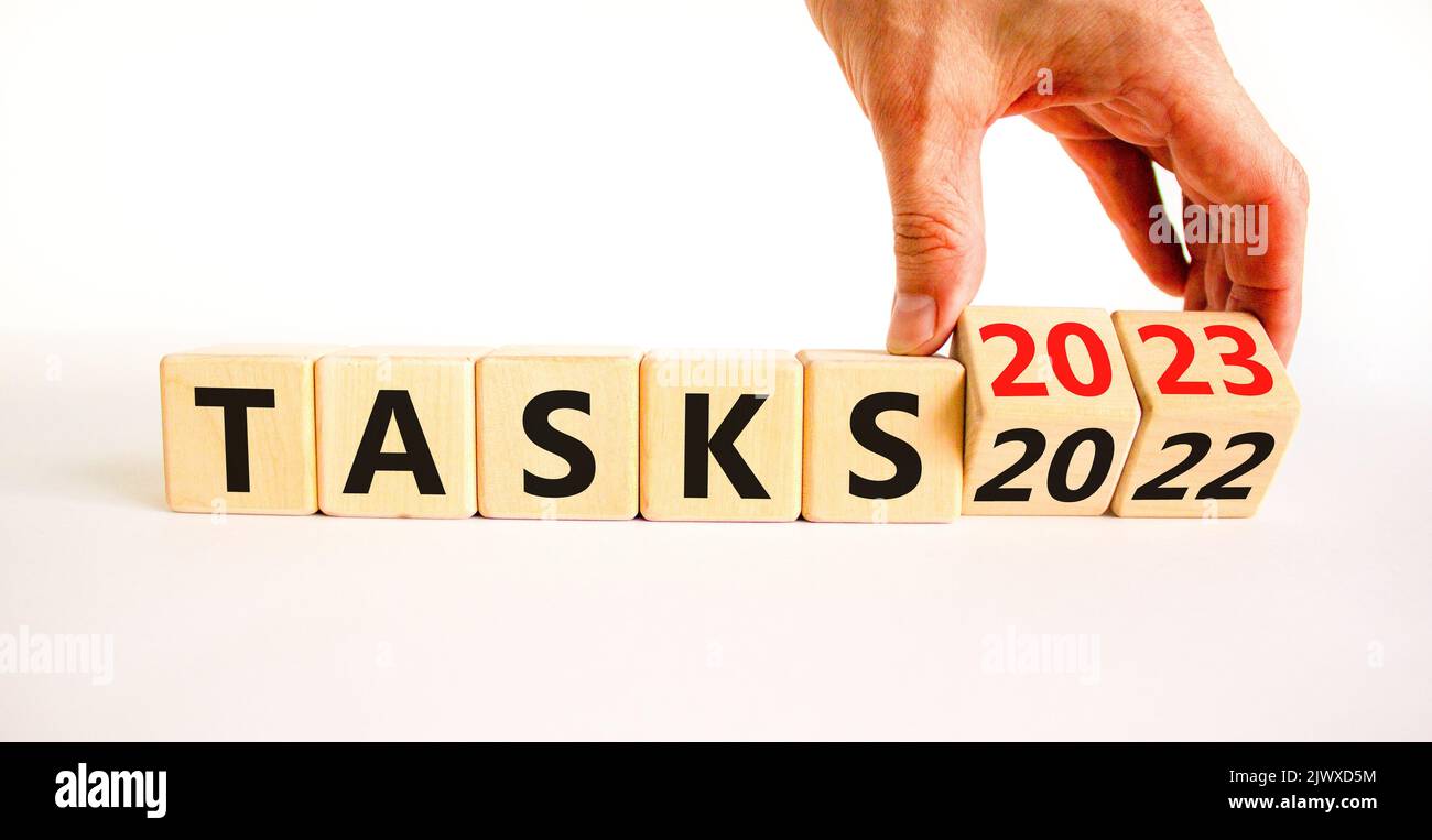 2023 tasks new year symbol. Businessman turns a wooden cube and changes ... 2023 tasks new year symbol. Businessman turns a wooden cube and changes ...