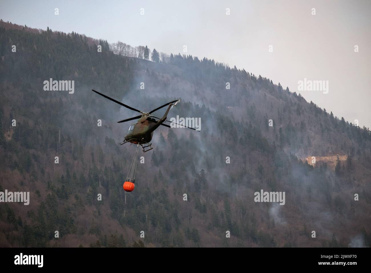 Localized wildfire with the helicopter dropping water by using a water ...
