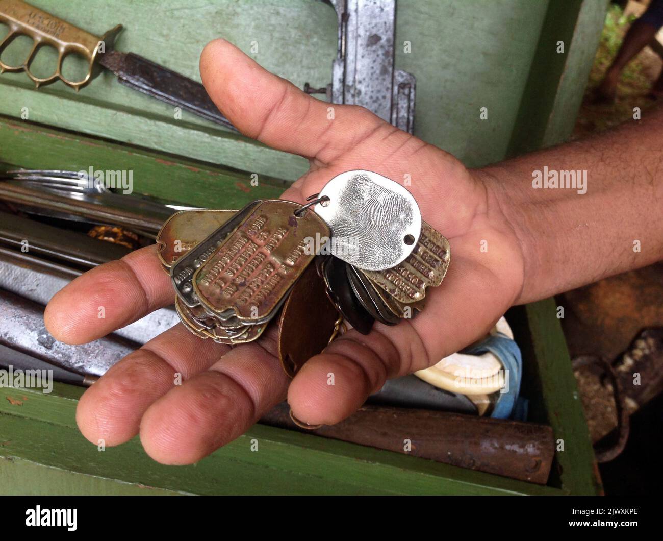 Barney Paulsen holds a bunch of US, Japanese and Dutch dog tags he has ...