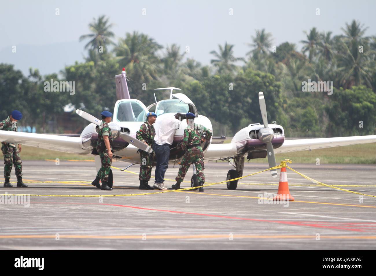 Indonesian air force officers check a small Australian plane and its ...