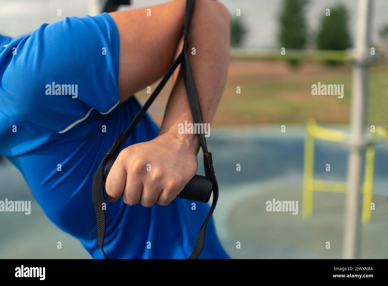 Close up hands of caucasian man during workout with suspension TRX on ...