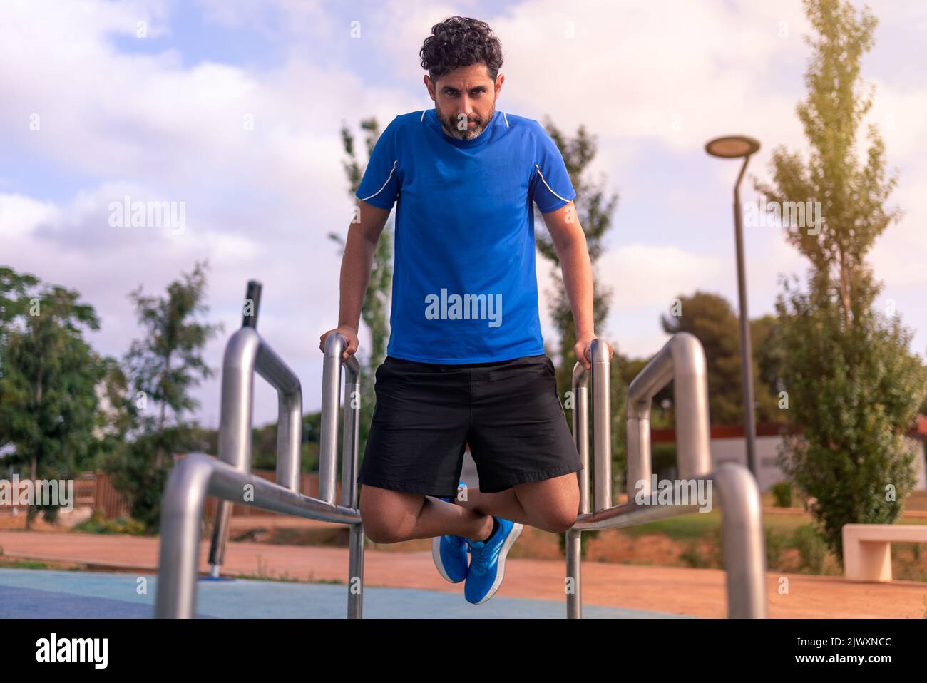 Sport man doing exercise push up. Caucasian person workout at city park ...
