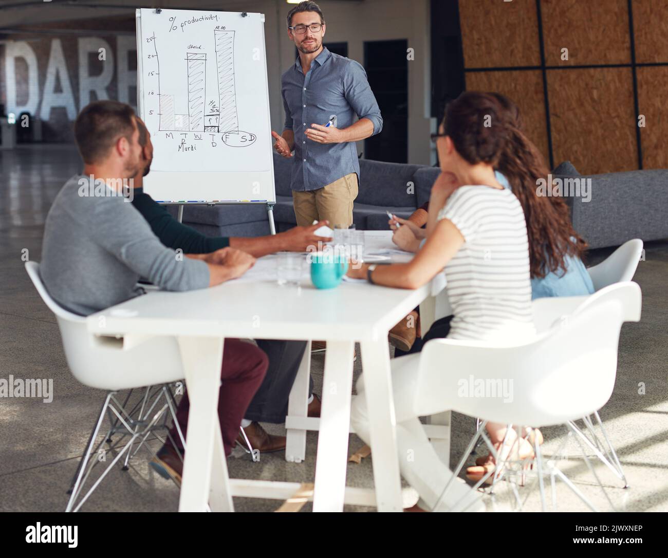 The creative process. a mature man giving a whiteboard presentation to ...