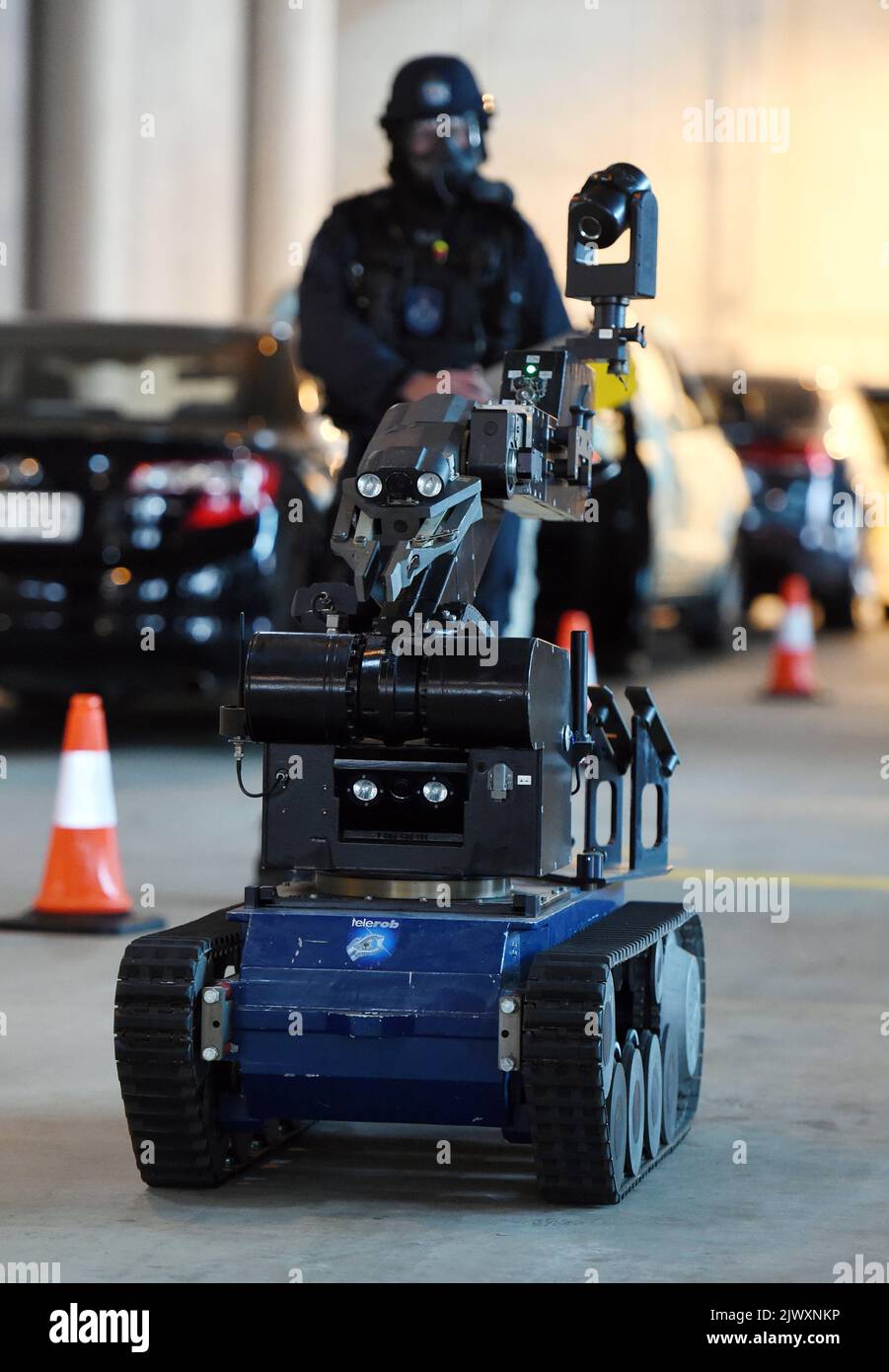 A police officer in tactical gear operates a bomb disposal robot during ...