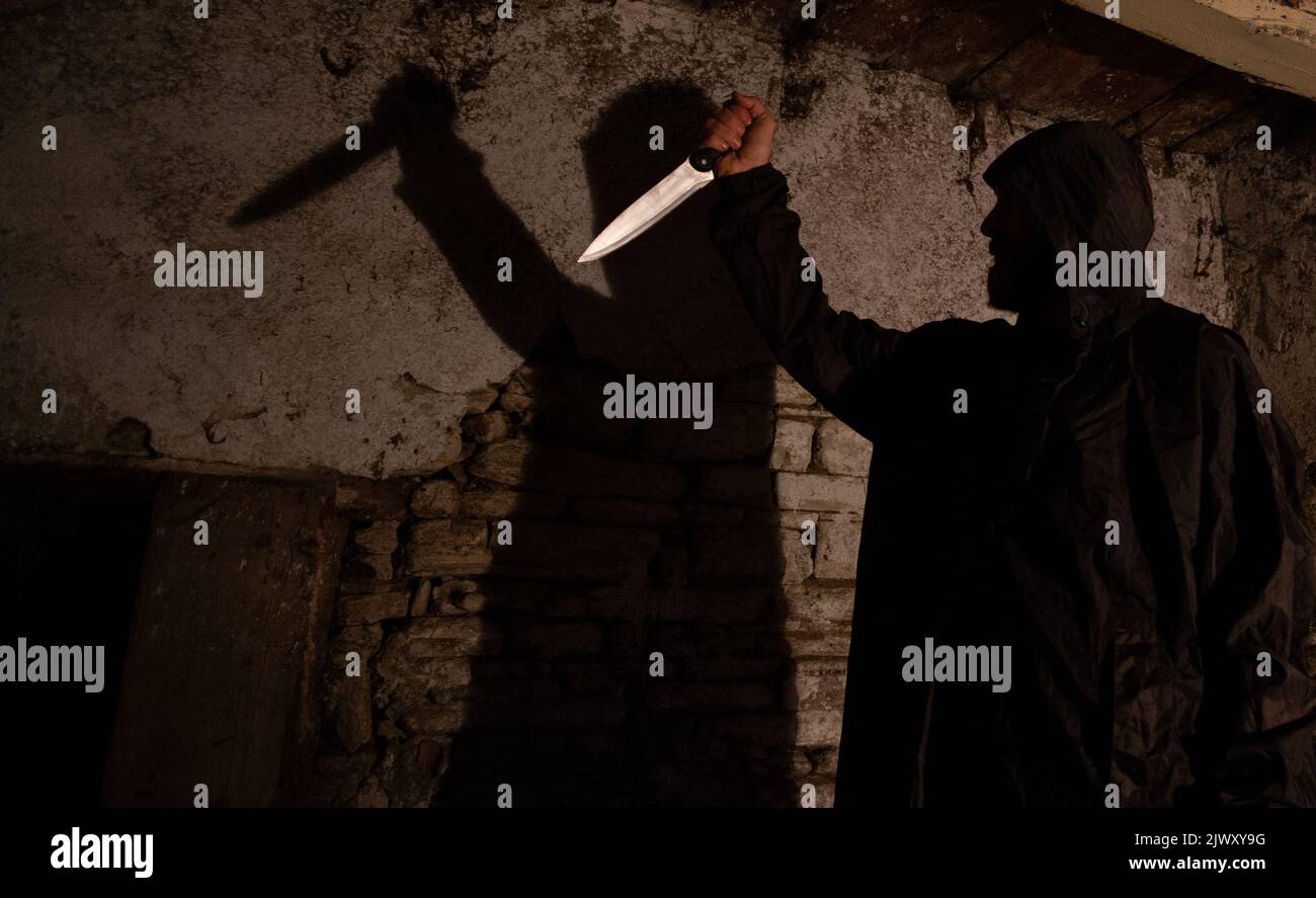murderer with big knife and shadow horror scene Stock Photo - Alamy