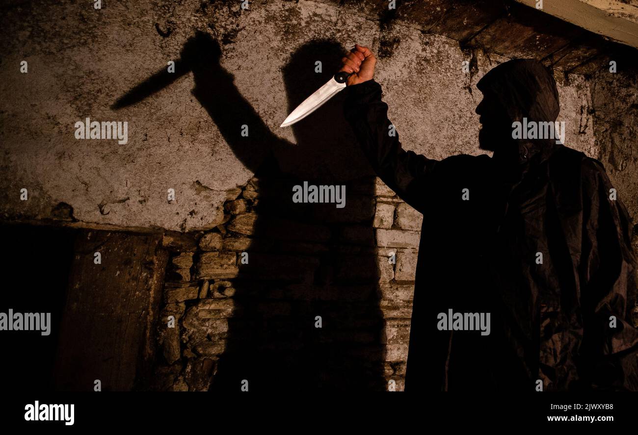 murderer with big knife and shadow horror scene Stock Photo - Alamy