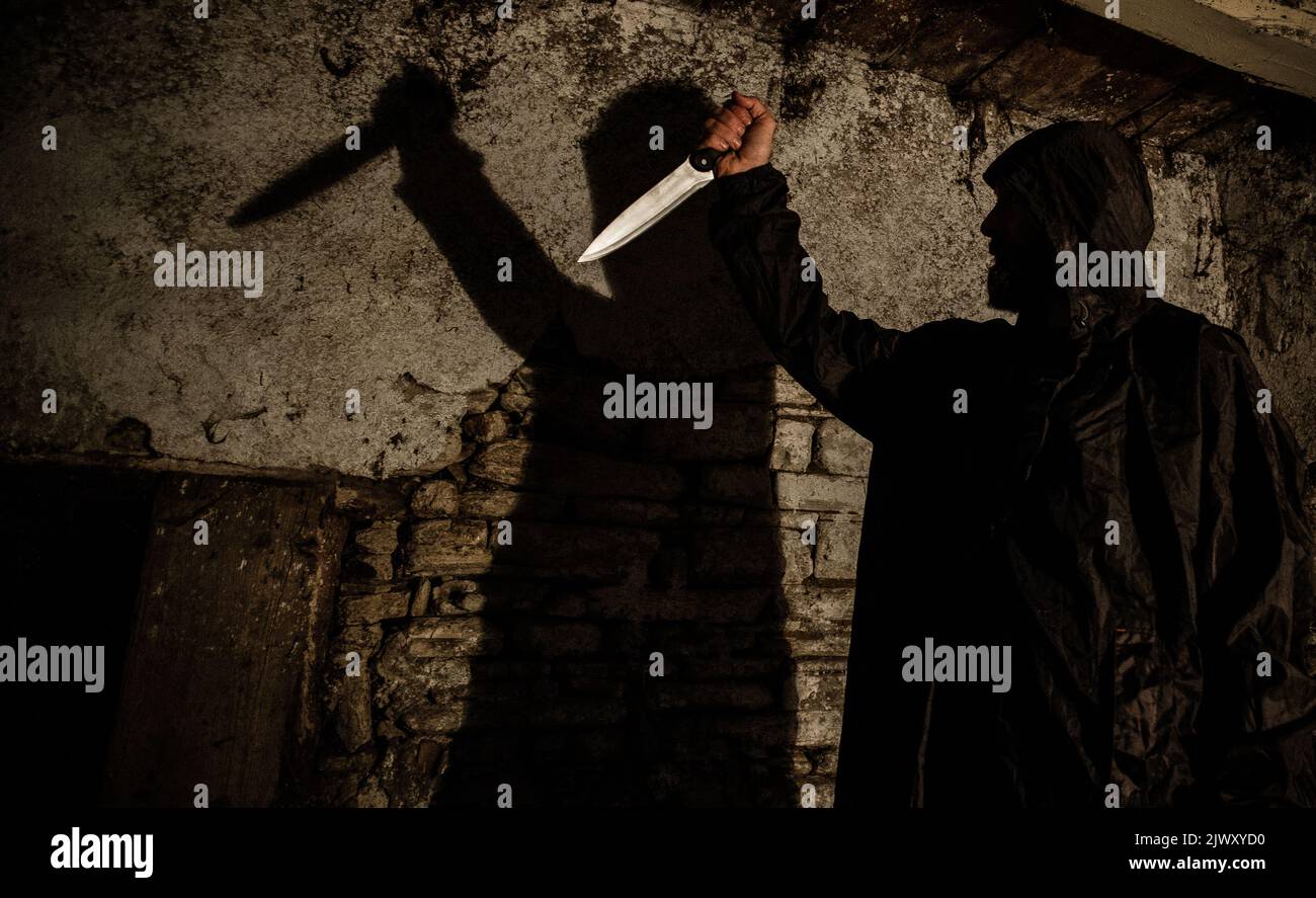 murderer with big knife and shadow horror scene Stock Photo - Alamy