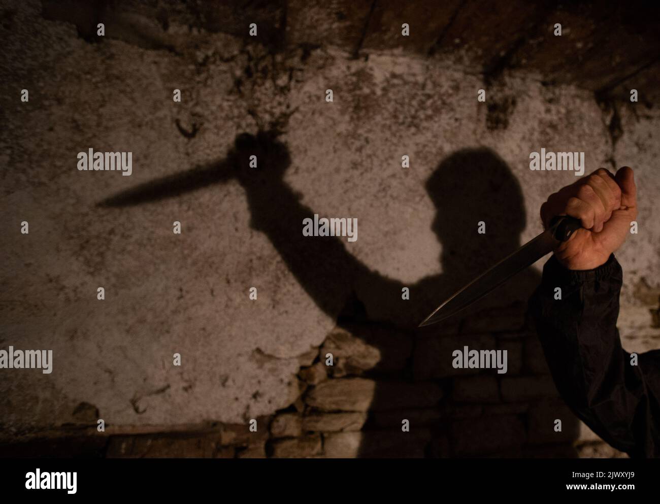 murderer with big knife and shadow horror scene Stock Photo - Alamy