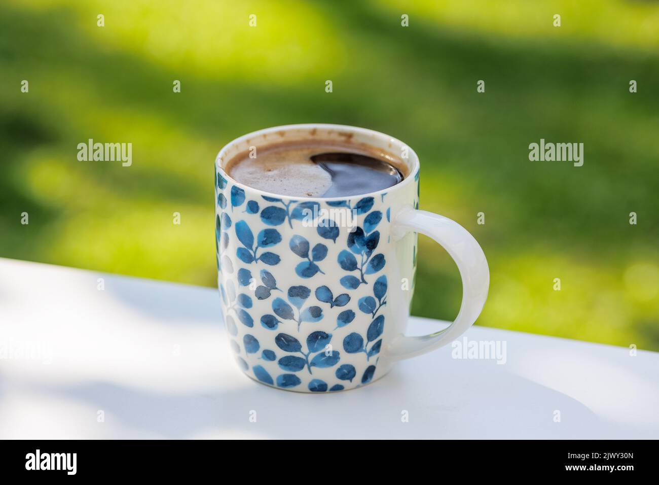 cup of coffee on white table in the garden, selective focus Stock Photo ...