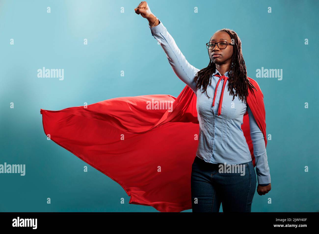 Powerful and brave young superhero woman wearing hero costume while ...