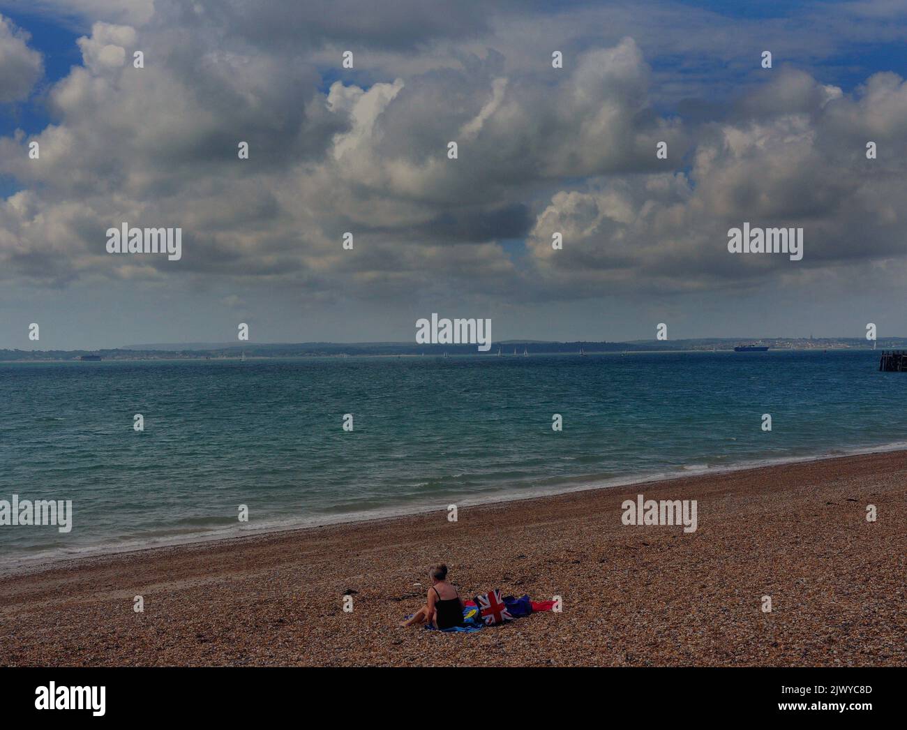 ONE HARDY SUNBATHER ON THE BEACH AT SOUTHSEA AS THE RAIN CLOUDS MOVE IN ...
