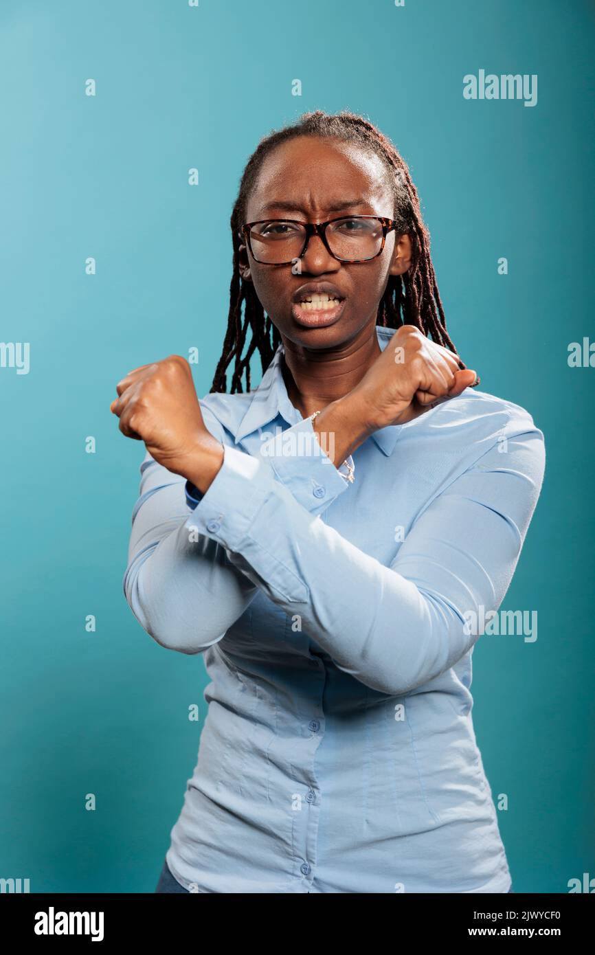 Angry and infuriated woman making decline crossed arms gesture while ...