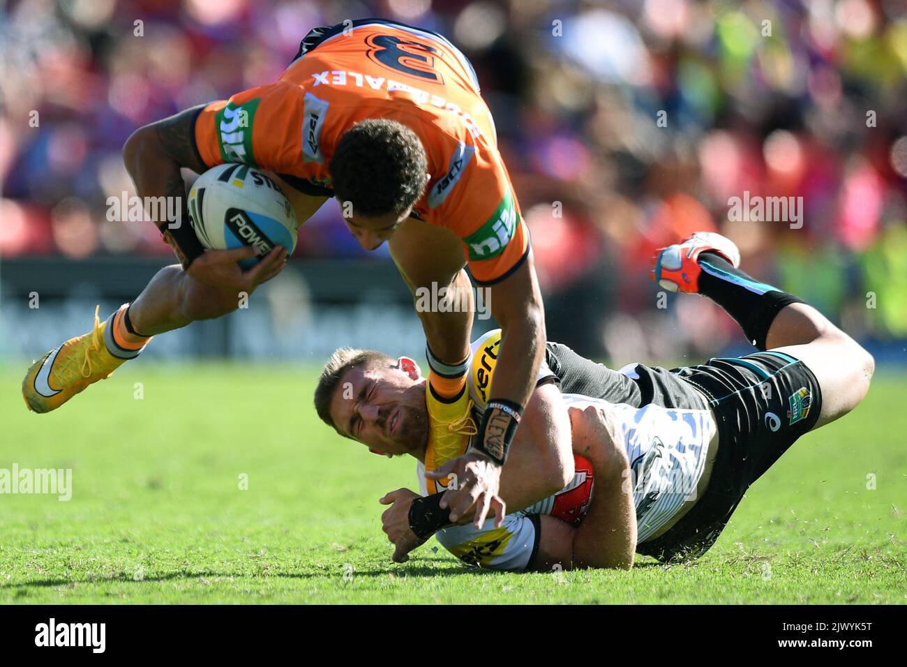 Dane Gagai of the Knights steps through a tackle by Bryce Cartwright of ...