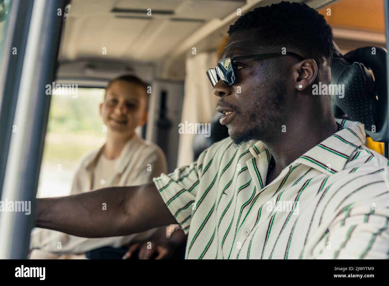 Dark-skinned young man driver close up. Multi-ethnic group of close ...