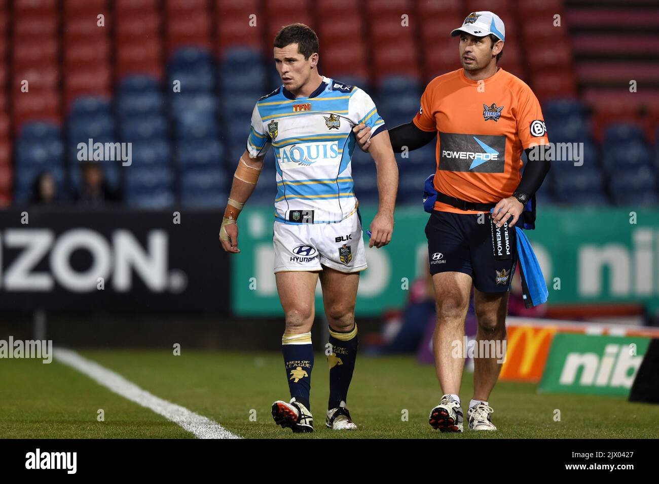 Daniel Mortimer (left) of the Titans is assisted from the field during ...