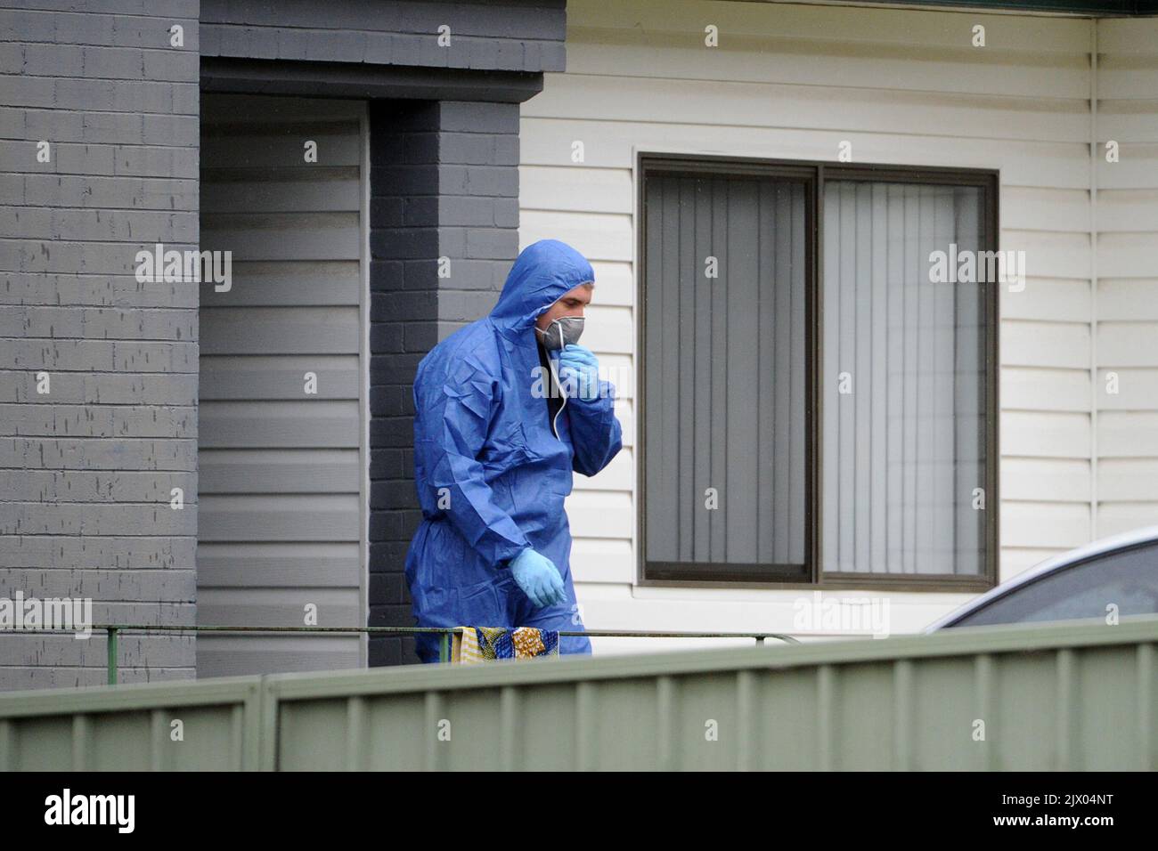 A New South Wales forensic officer is seen leaving a property where a ...