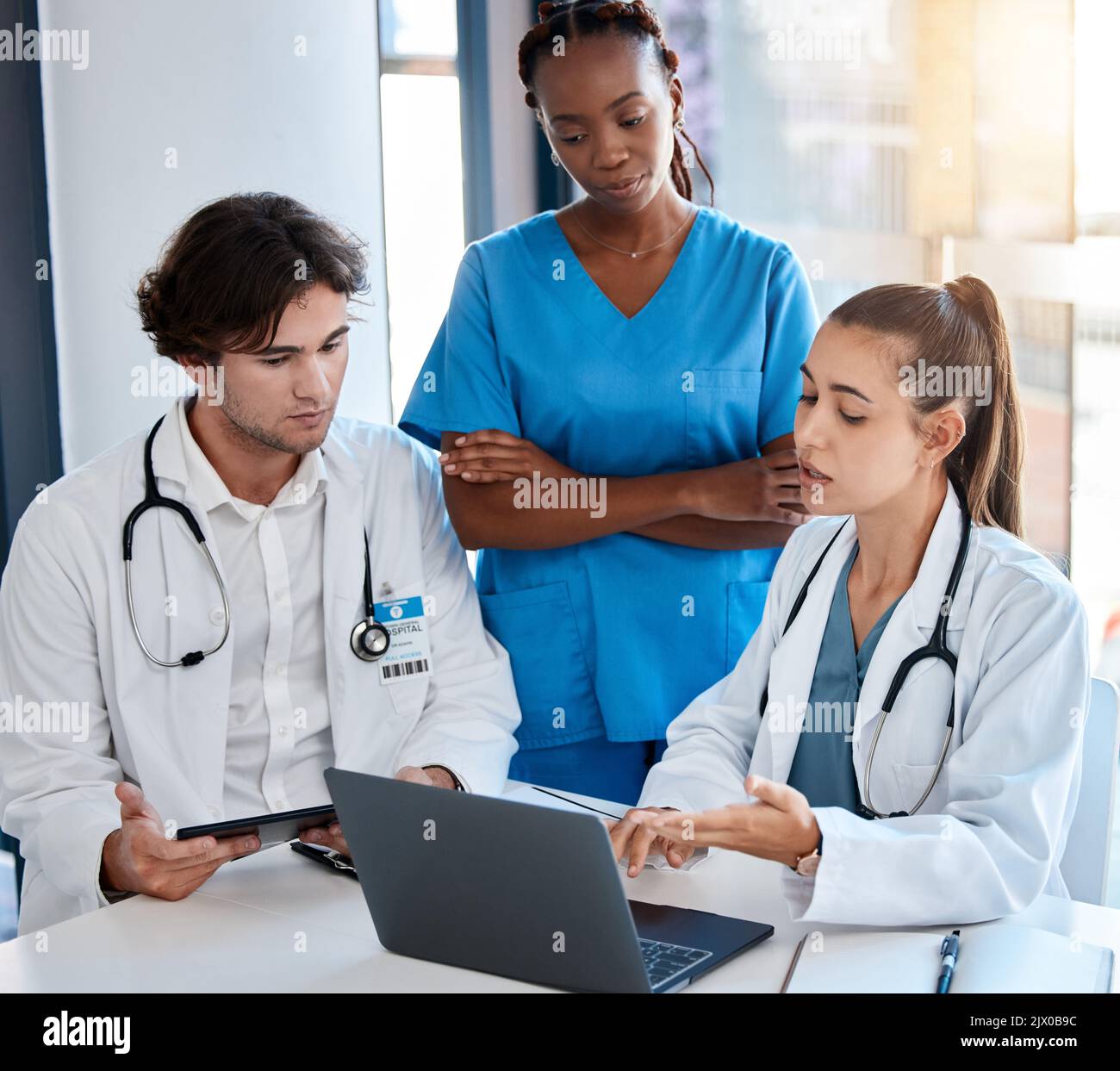 Teamwork, doctors and collaboration on laptop during a meeting in a ...