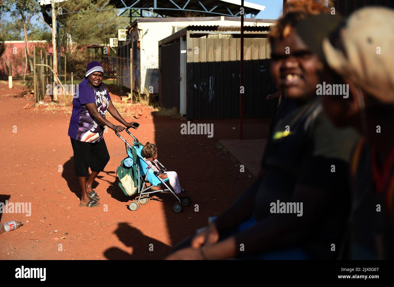 A young mother arrives at a community centre with her child at the ...