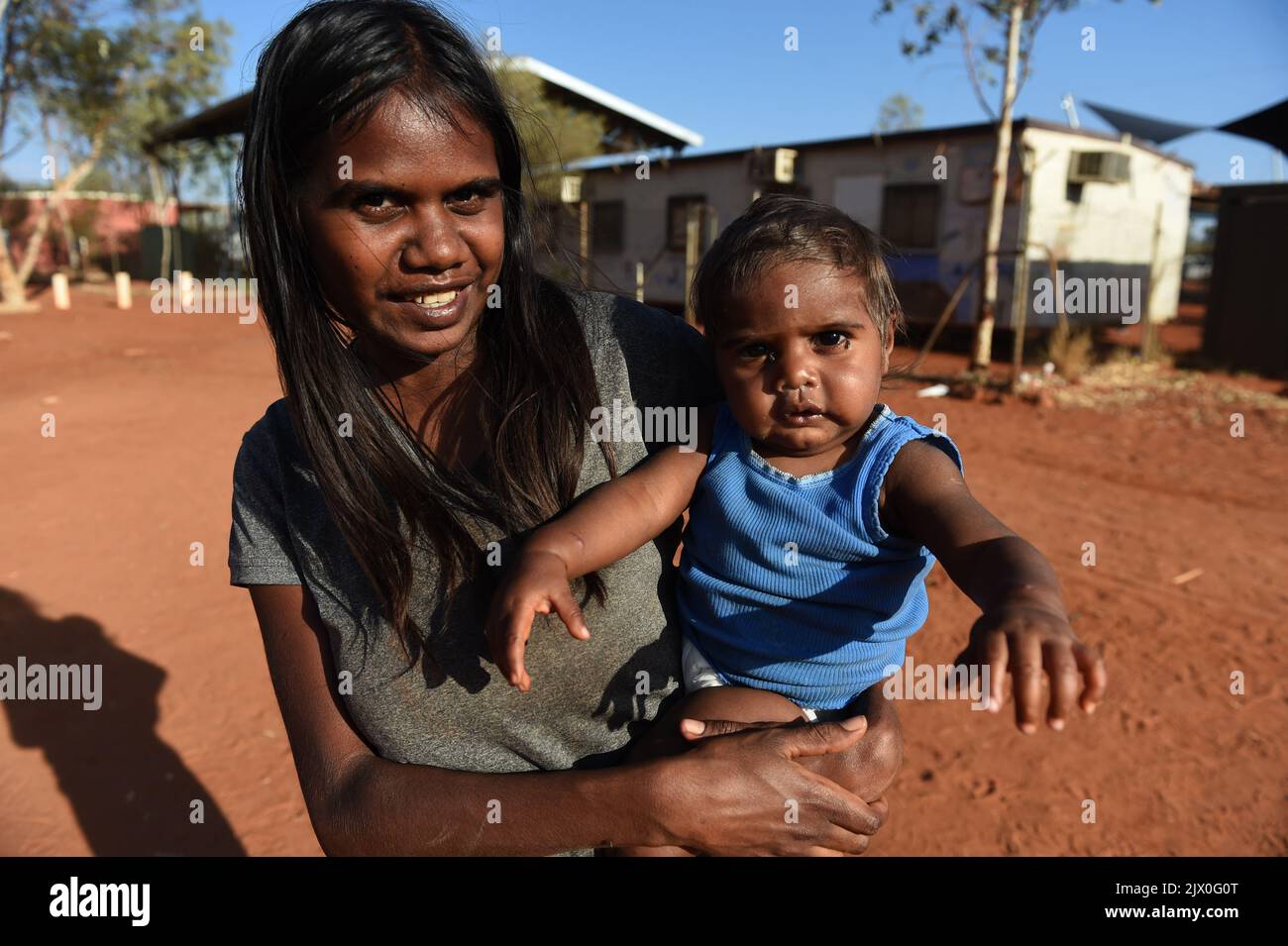 A young mother poses for a photo with her child at the Mutitjulu ...