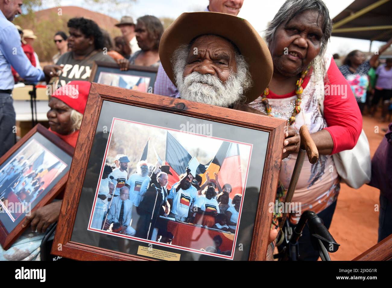 Reggie Uluru holds a frames photograph of himself at the original ...