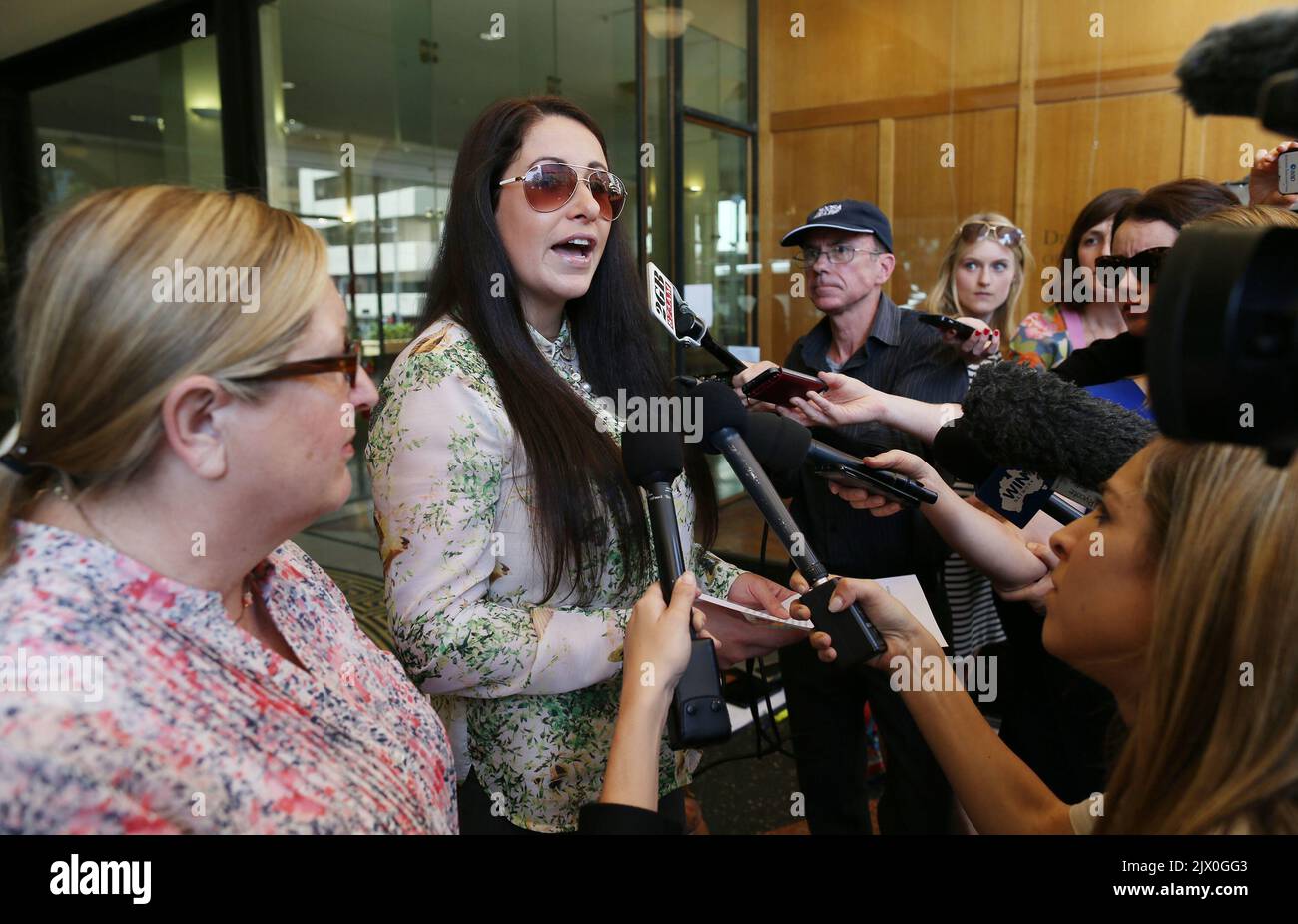 Tara Hodge (centre), the sister of Dwayne Nicholson, speaks to the ...