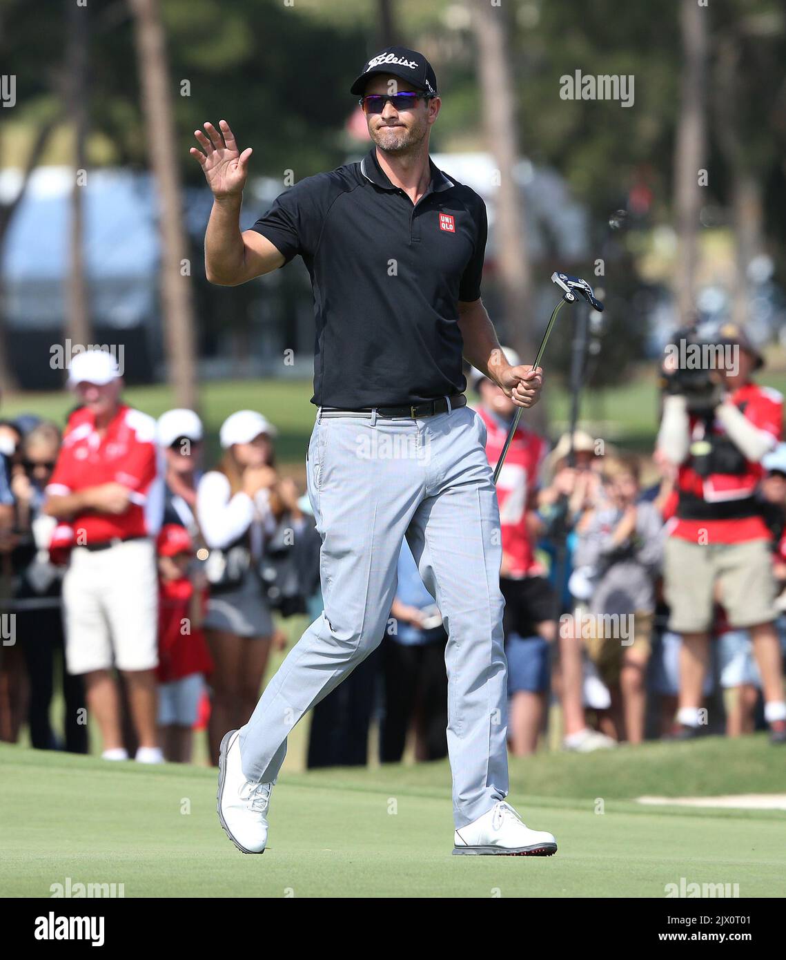 Australia's Adam Scott gestures to the crowd after making his birdie on ...