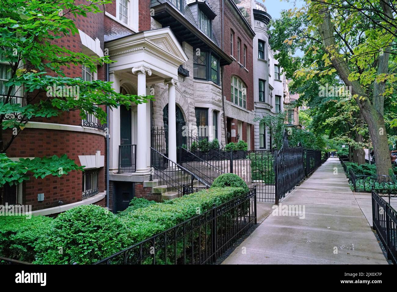 Urban residential street with older townhouses and small apartment ...