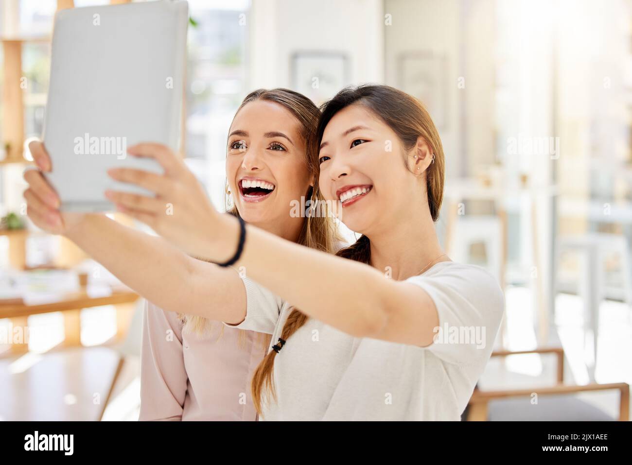 Tablet, happy and women taking a selfie at work on a break to post it ...