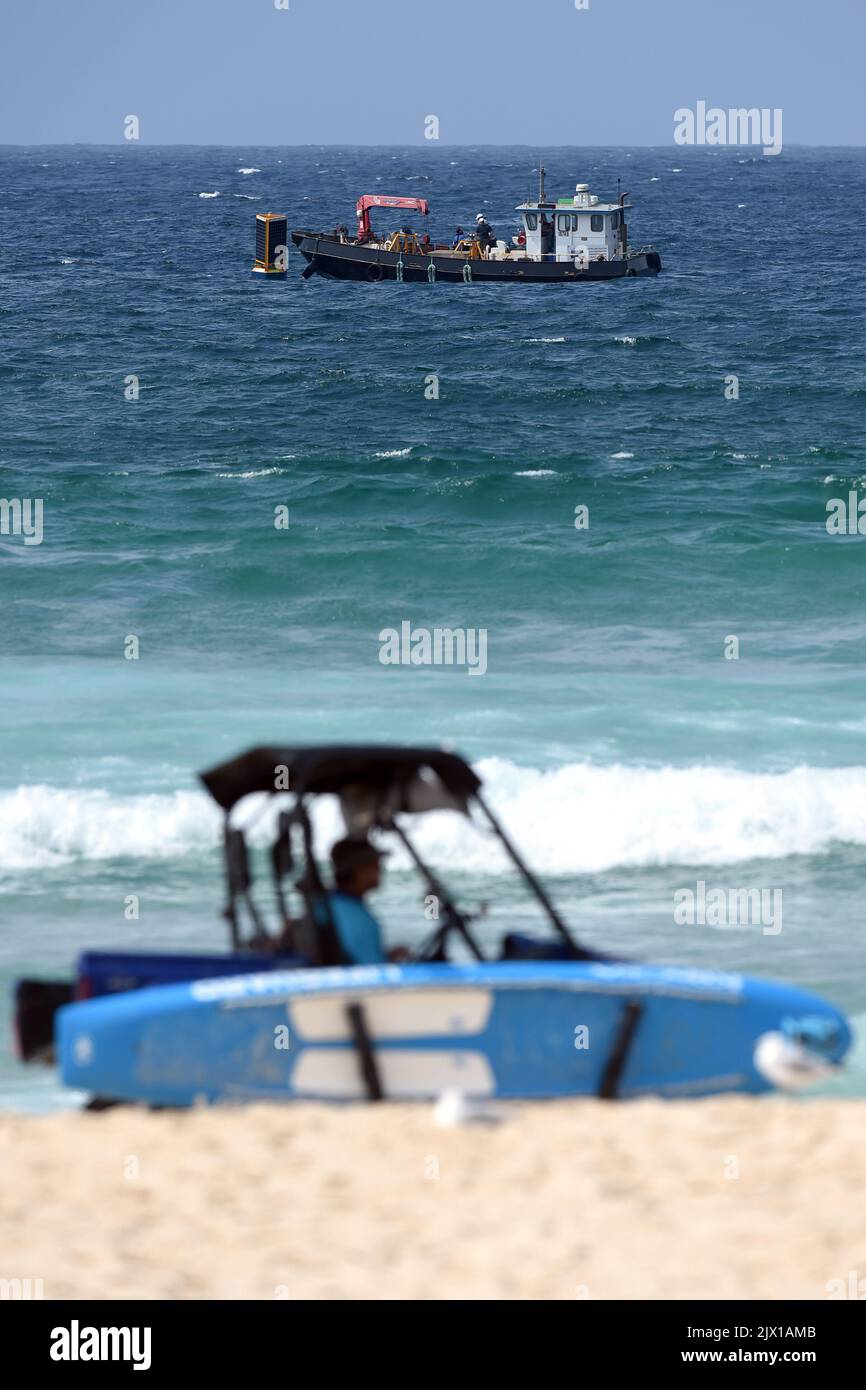 A lifeguard passes by as the 'Clever Bouy' shark detection system is ...