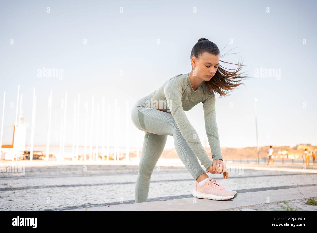 Female runner stretching before running. Side view confident fitness ...
