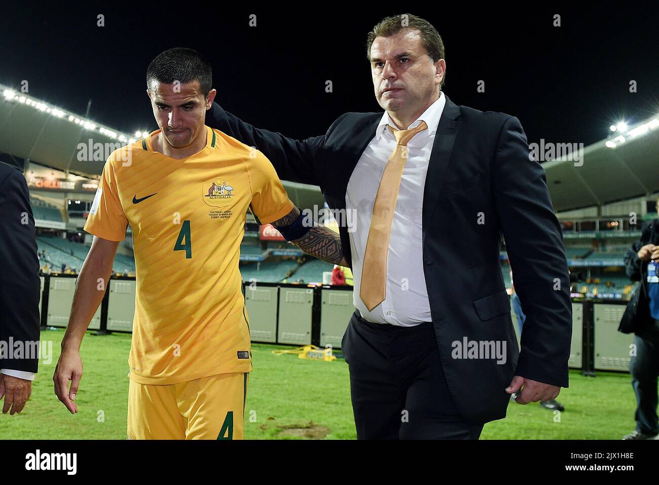 Tim Cahill of Australia and coach Ange Postecoglou leave the field ...