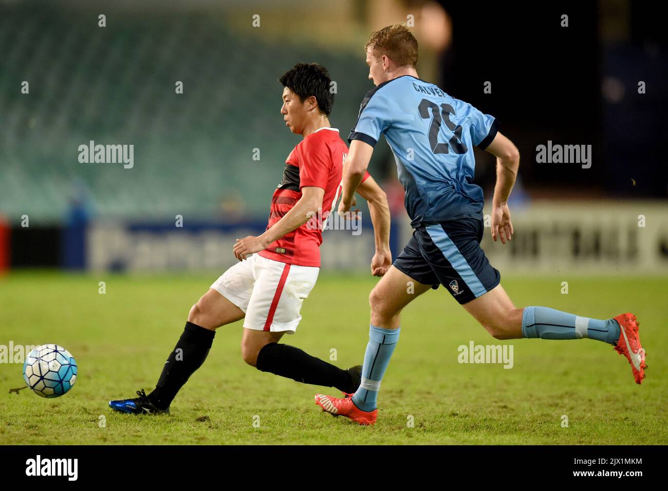 Muto Yuki of the Urawa Red Diamonds comes under pressure from Alex ...