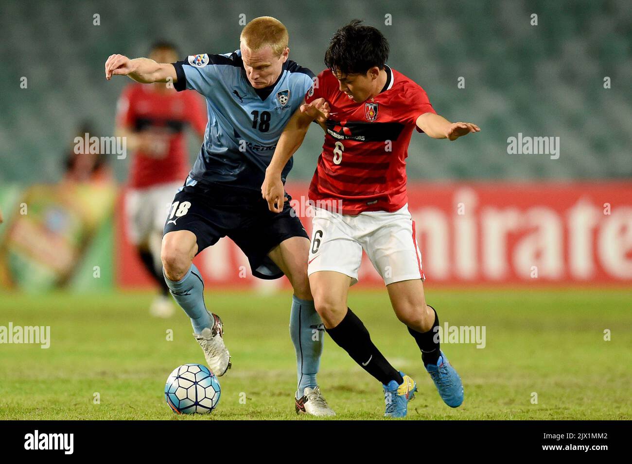 Matthew Simon of Sydney FC is tackled by Endo Wataru of the Urawa Red ...