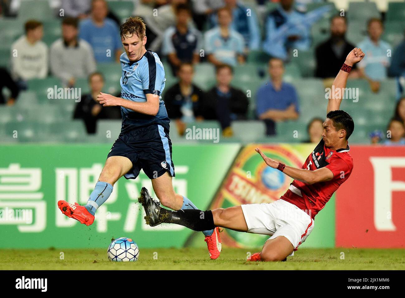 Aaron Calver of Sydney FC is tackled by Makino Tomoaki of the Urawa Red ...