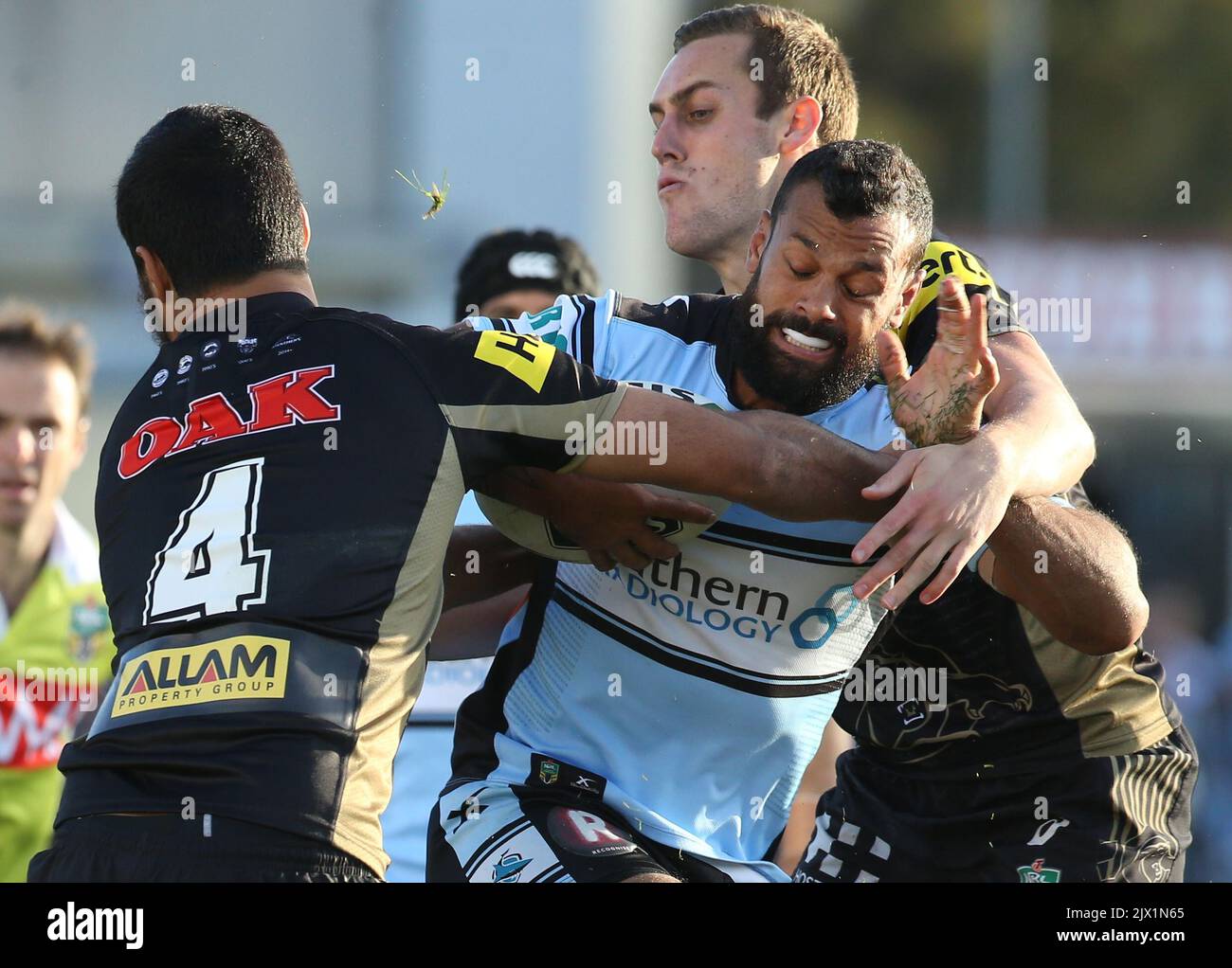 Jayson Bukuya of the Sharks tackled by Peta Hiku and Isaah Yeo of the ...