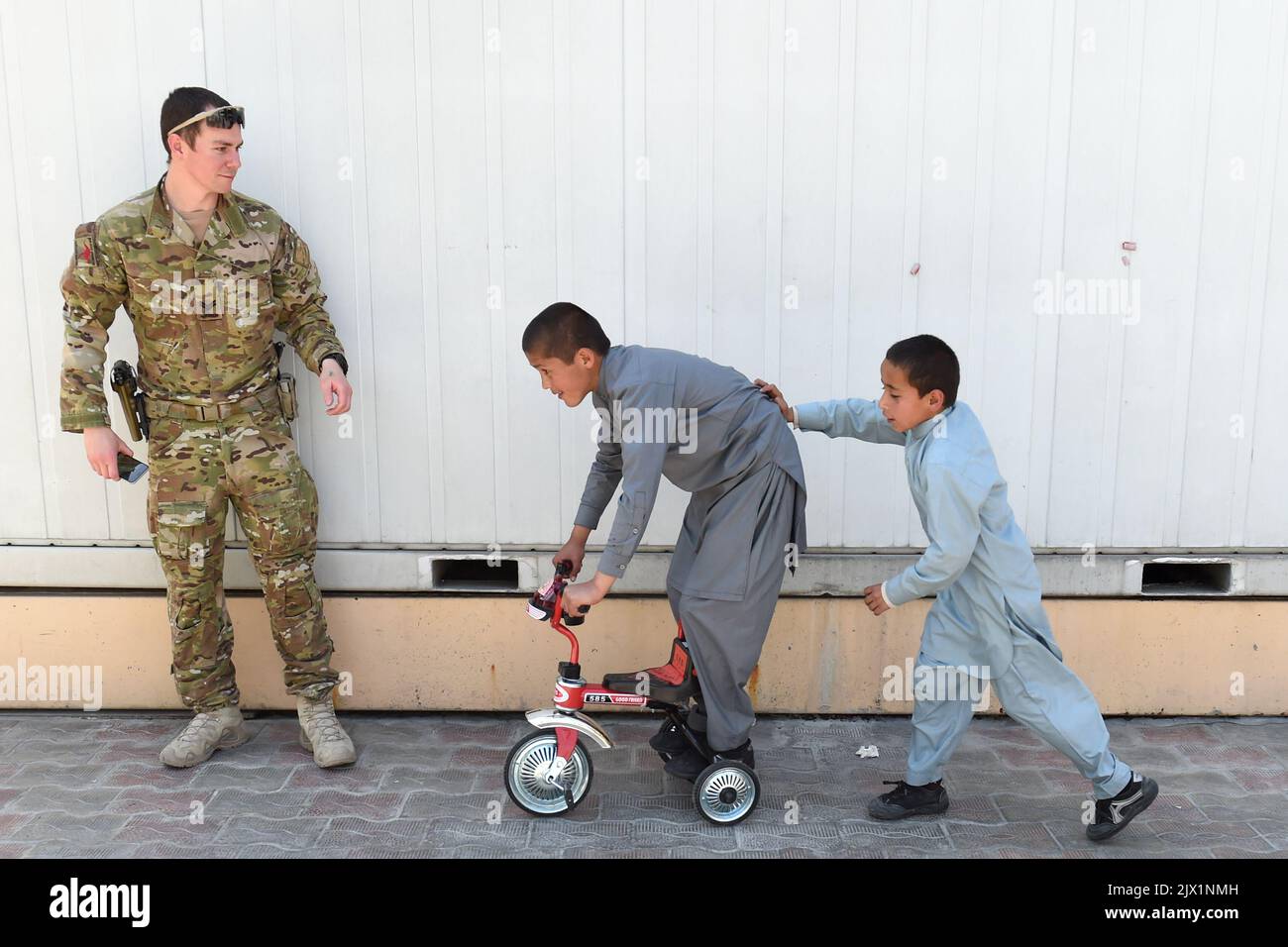 An Australian Defence Force soldier watches as orphans play during a ...