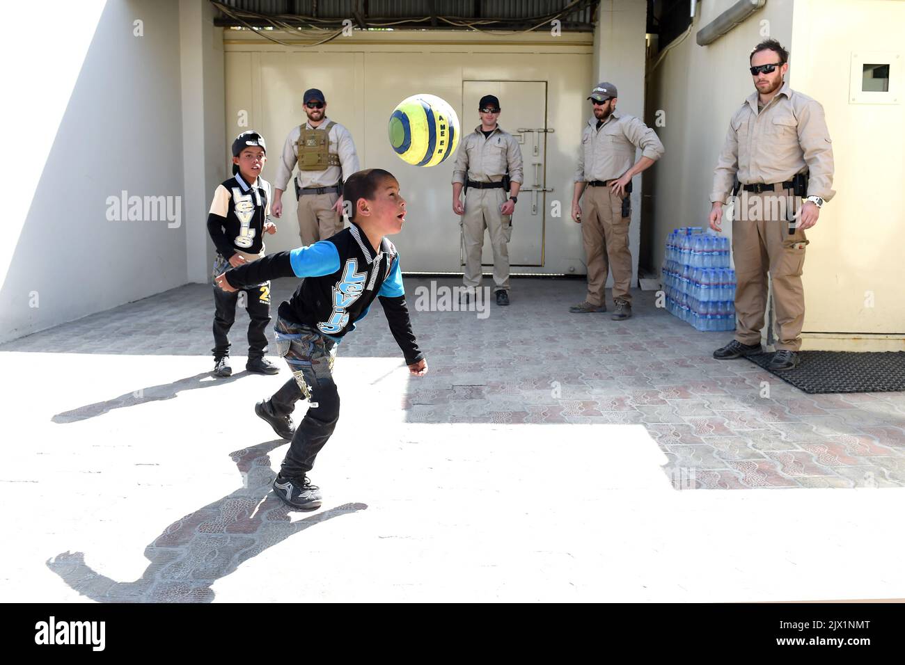 Security contractors watch orphans play during a visit to an Australian ...