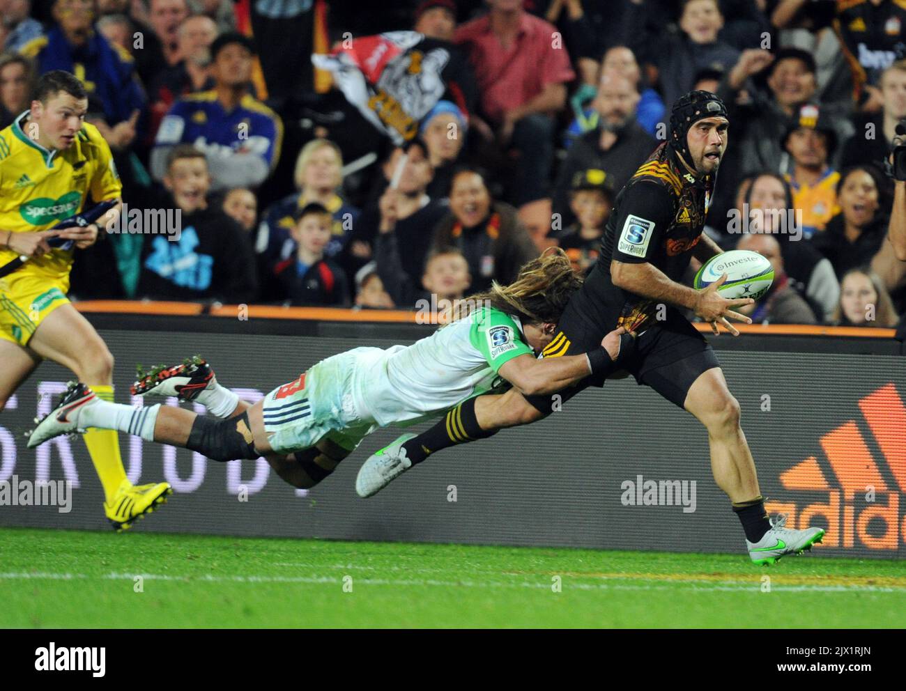 Dan Pryor of the Highlanders, left, hangs off the back of Charlie ...